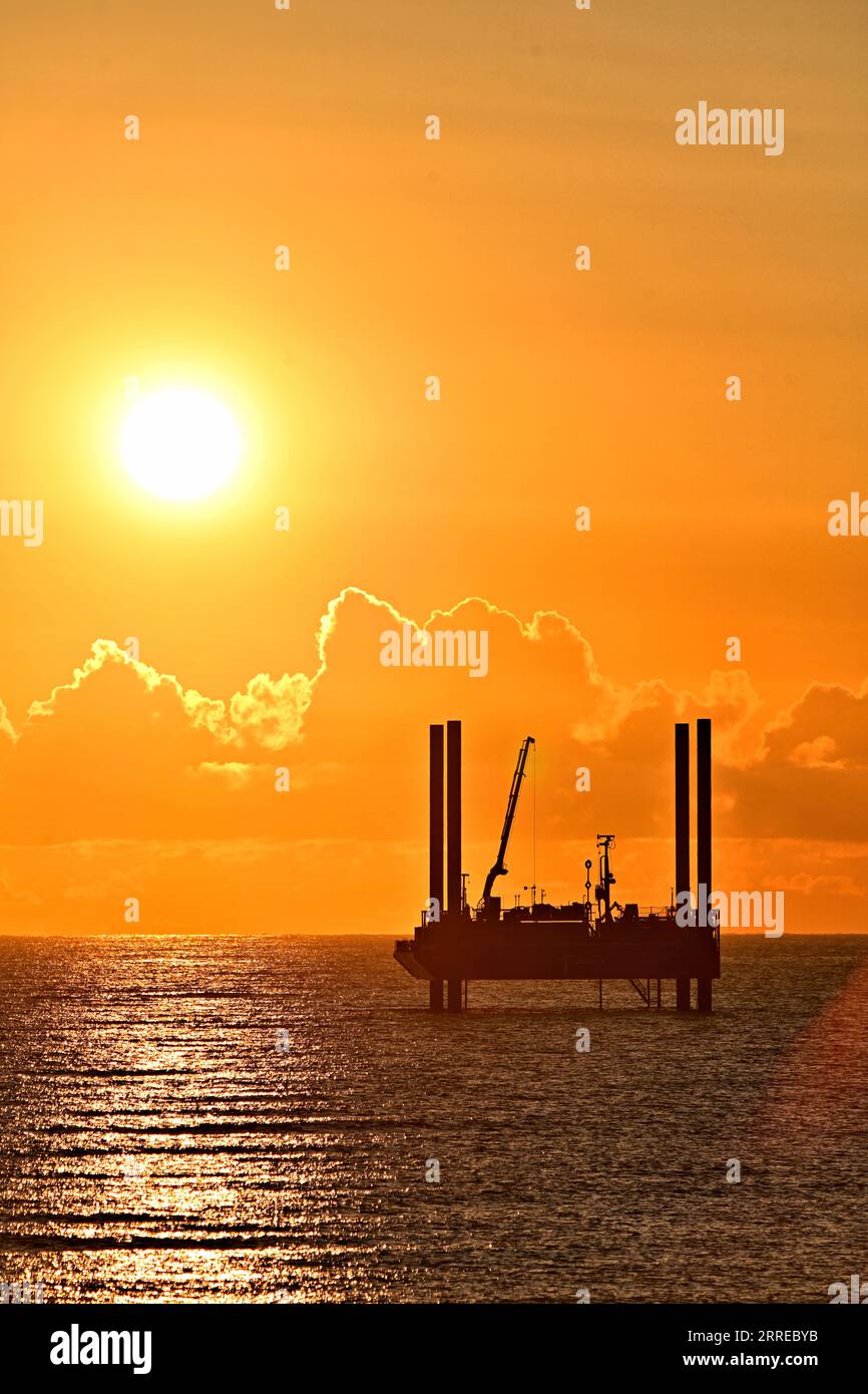 Drilling test rig ARAN250 jackup with gold rimmed horizon cloud orange ...