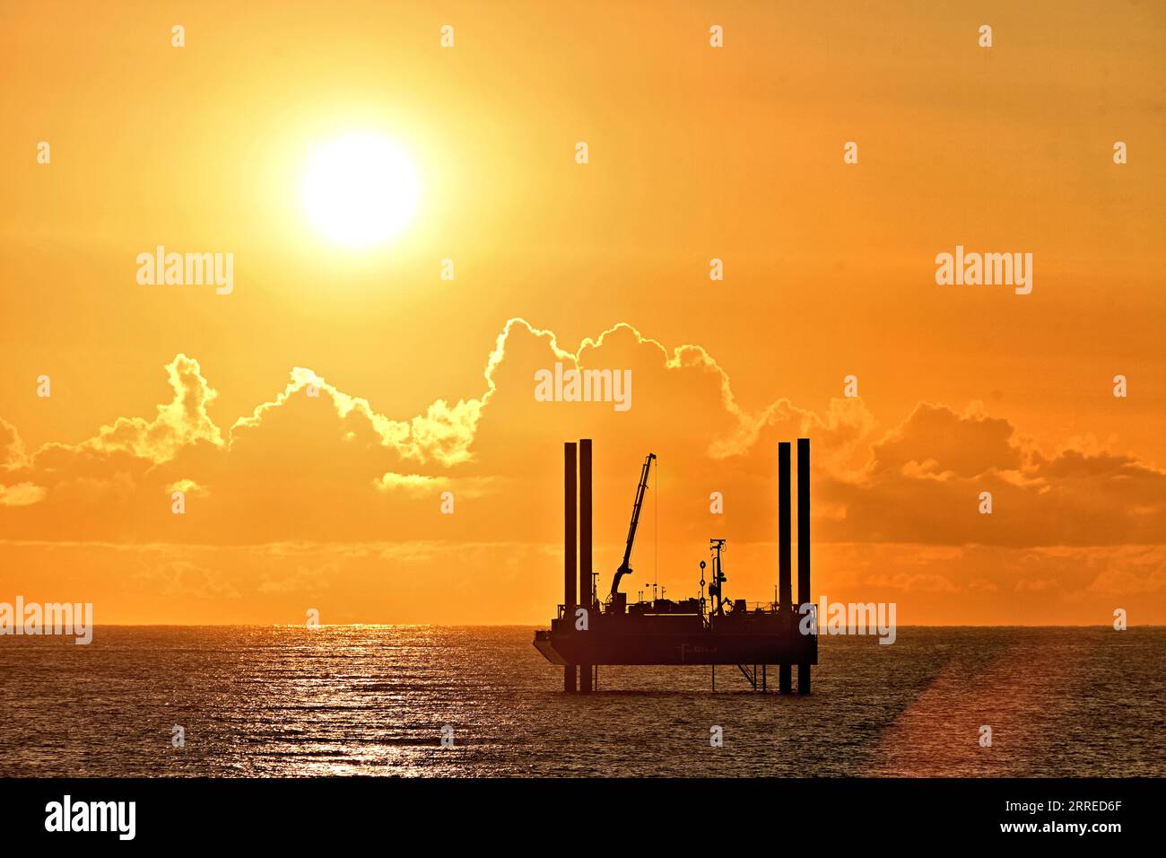 Drilling test rig ARAN250 jackup with gold rimmed horizon cloud orange ...