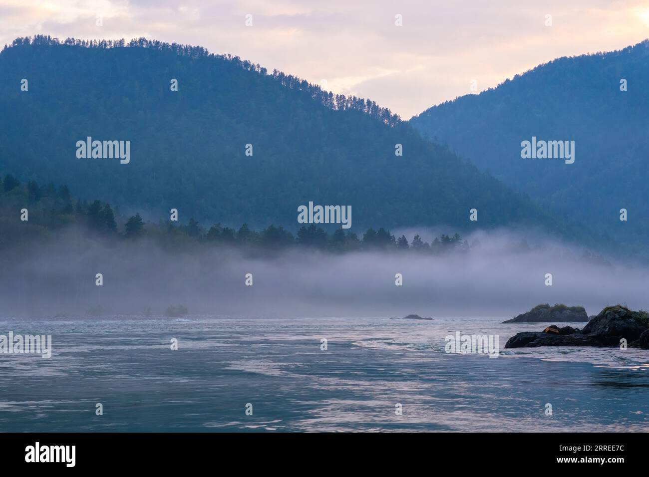 A wide, full-flowing mountain river with a fast current Stock Photo - Alamy