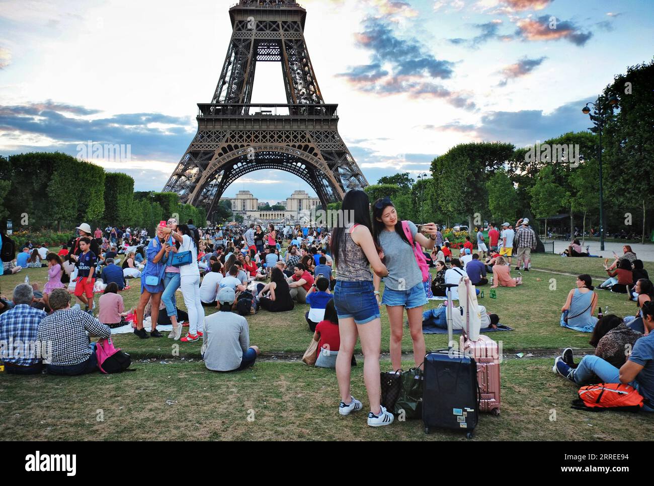 Women taking selfies with the Eiffel Tower at dusk on the Champs de ...
