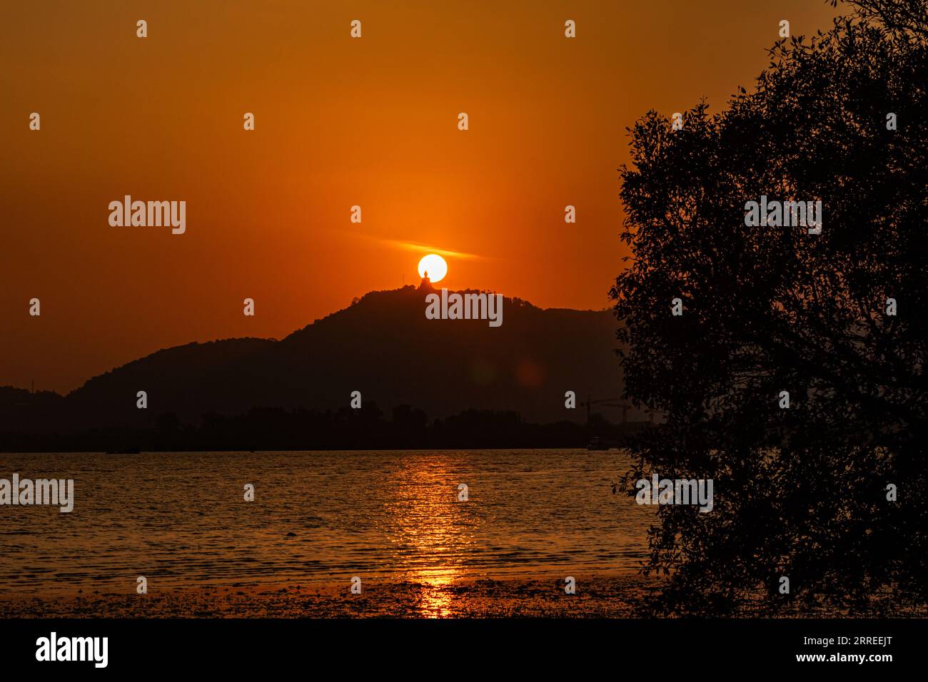 The sun circles in the red sky behind the Big Buddha. Amazing Phuket ...