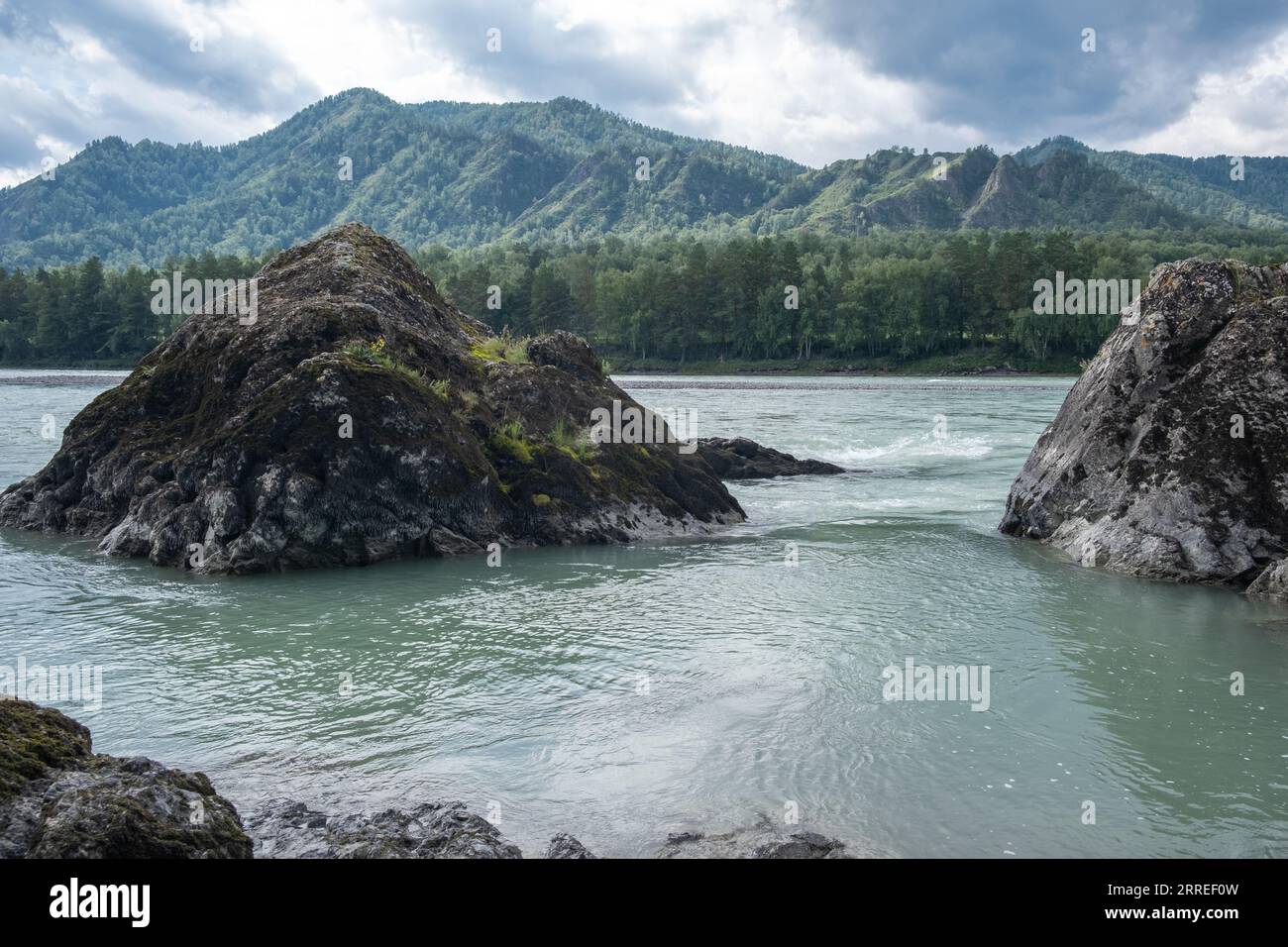 A wide, full-flowing mountain river with a fast current Stock Photo - Alamy