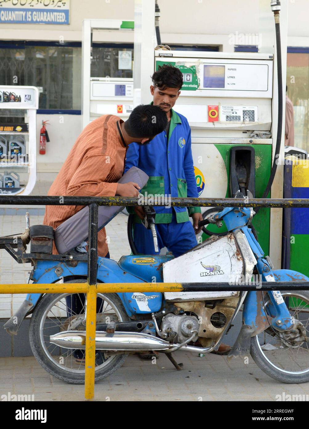 220301 -- KARACHI, March 1, 2022 -- An employee fills tank of a ...