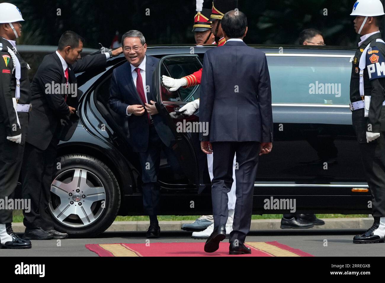 Chinese Premier Li Qiang, third left, steps out from his car as ...