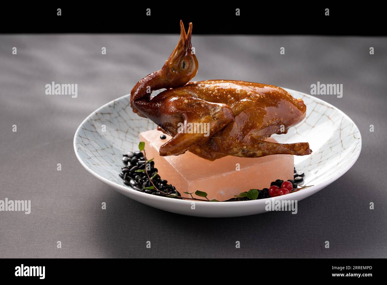 Traditional Cantonese grilled pigeon on a white porcelain plate，Crispy ...