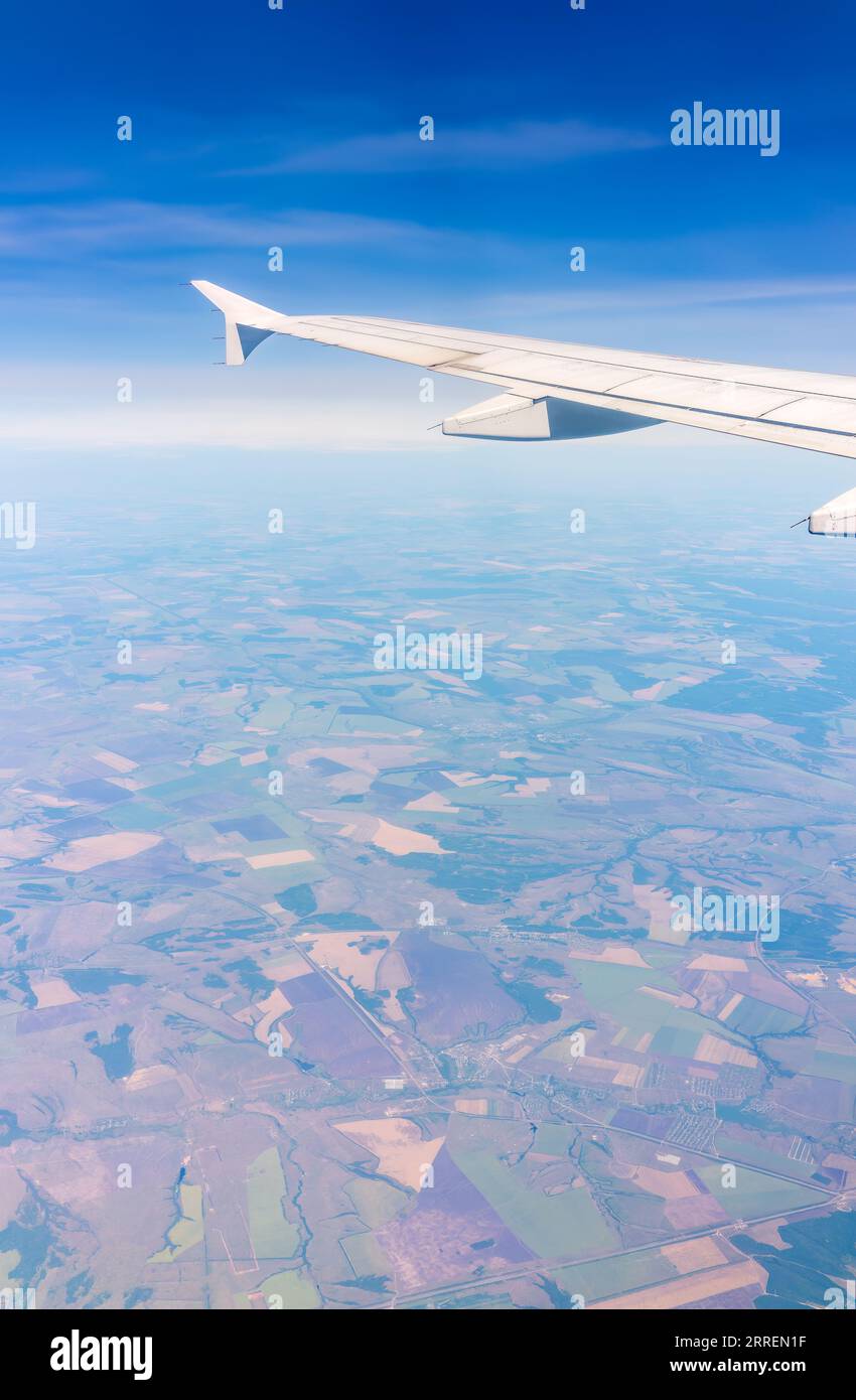 Aerial view from airplane window above green ground. View from the ...