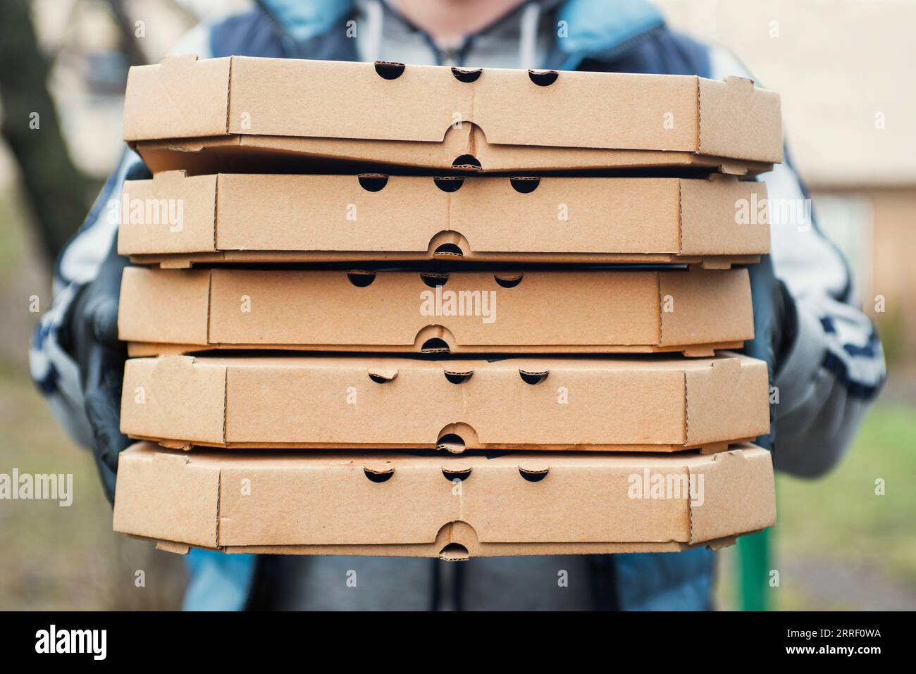 Man delivering pizza. A Deliveryman is holding a large stack of pizza ...