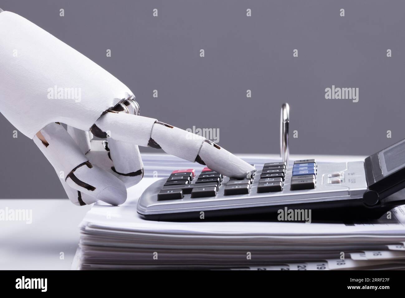 Close-up Of A Robotic Hand Calculating Bills Using Calculator In Office ...