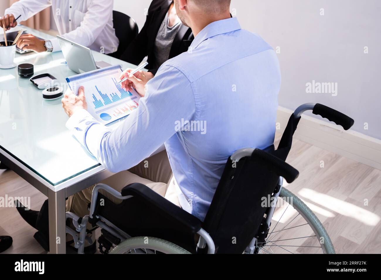 Disabled Male Manager Sitting With His Colleagues At Workplace Stock ...