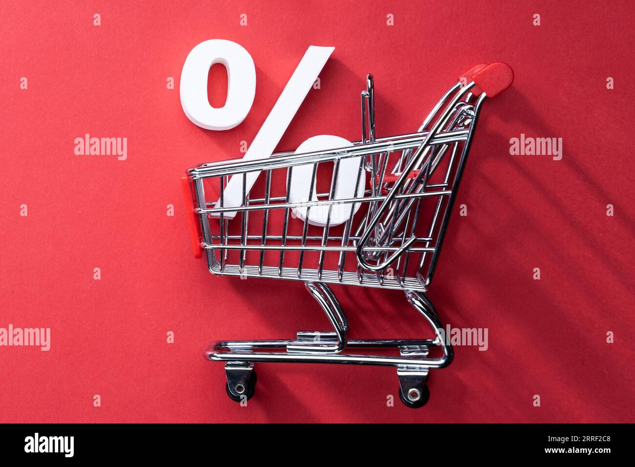 Sale Percents Falling Into Shopping Cart On Red Background Stock Photo ...
