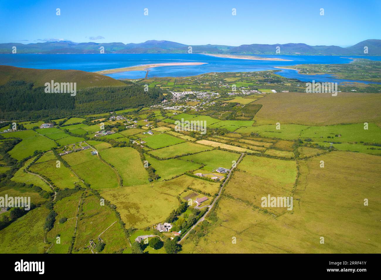 An aerial view of a coastal town with blue sky in Glenbeigh, Kerry ...