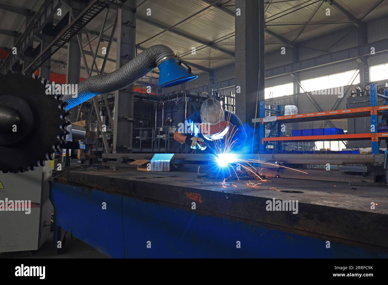 The workers are welding the mechanical parts in the factory Stock Photo ...