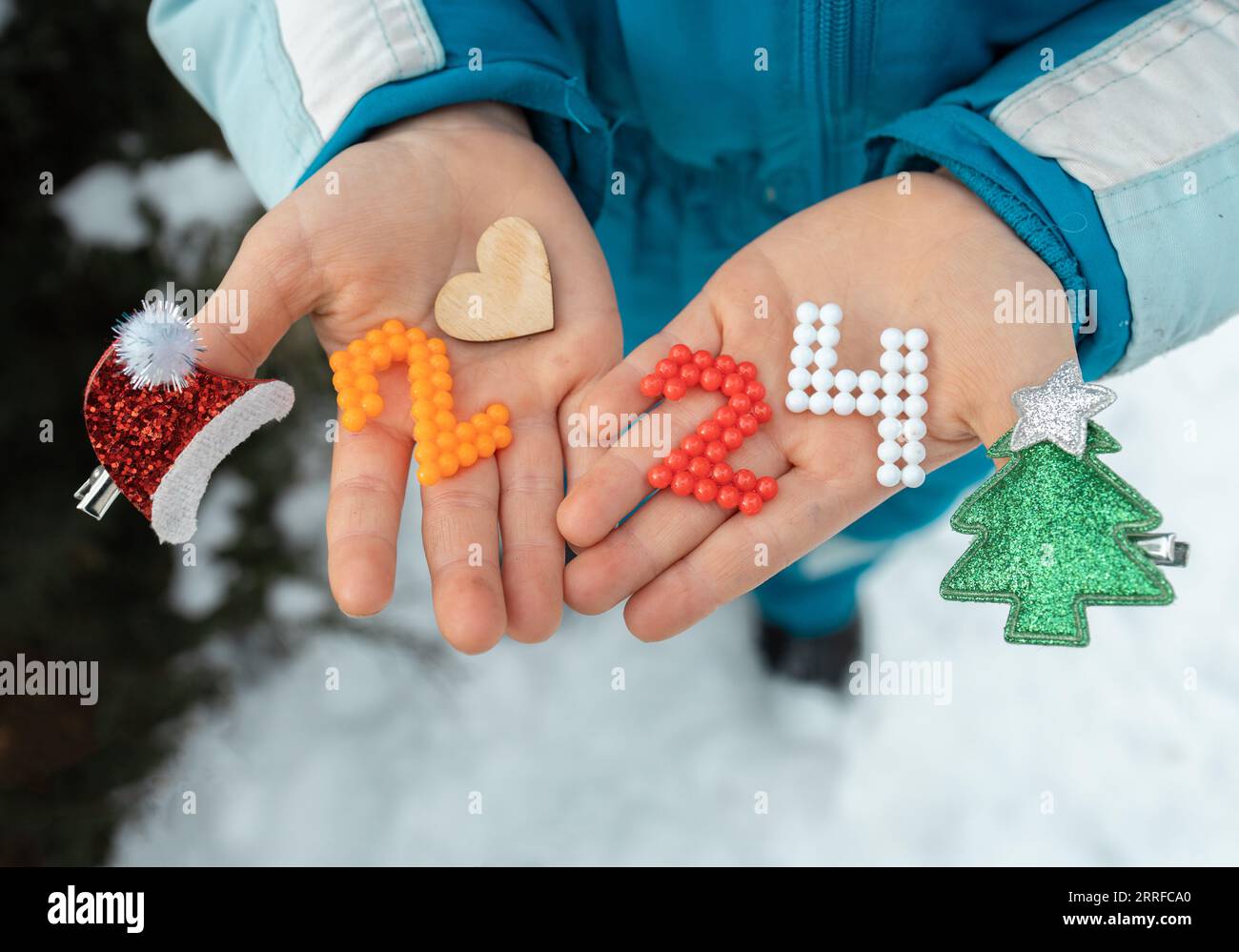 child holds the numbers 2024 on his palms, a Santa hat and a Christmas ...