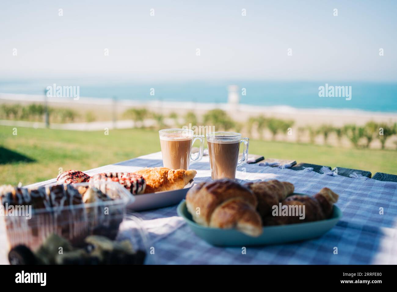 A picnic at the seaside beach. Breakfast with coffee, croissants and ...