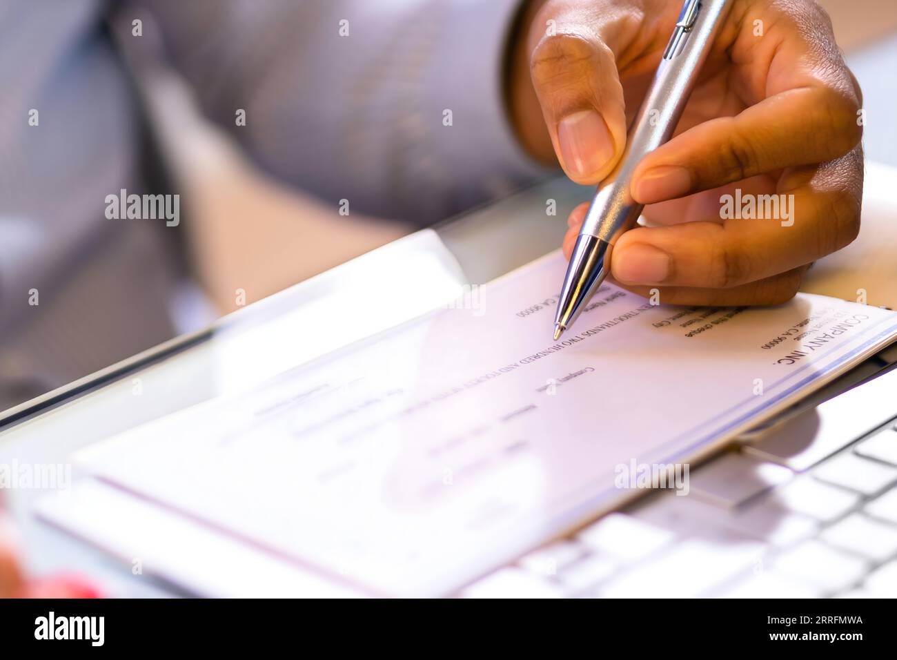 Writing Payroll Compensation Check. Bank Pay Cheque Stock Photo - Alamy