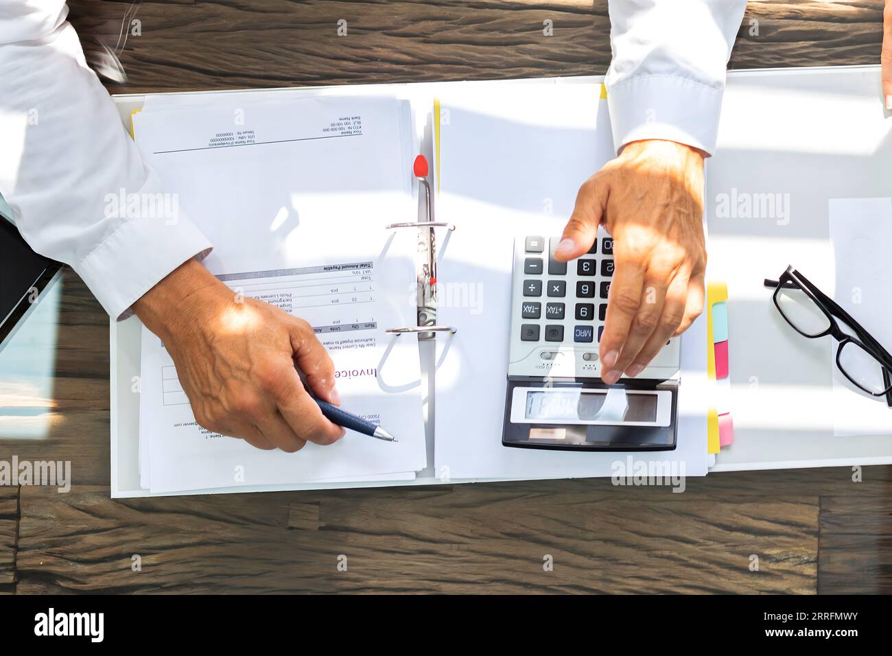 An Overhead View Of Businessman Calculating Invoice In Office Stock ...