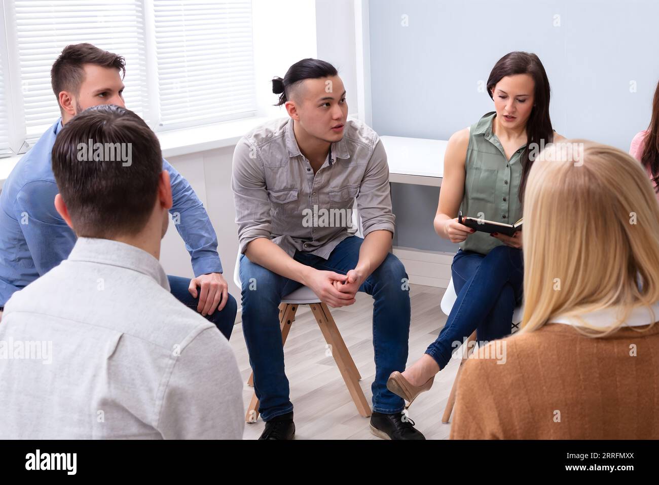 Young Multiracial Millennial Friends Sitting In Circle Having Group ...
