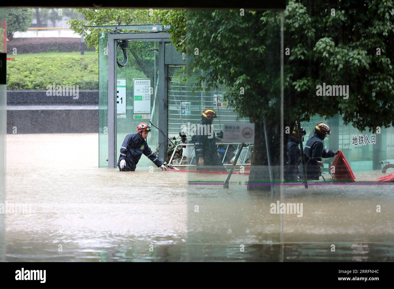 Workers try to protect the entrance of a subway station from flooding ...
