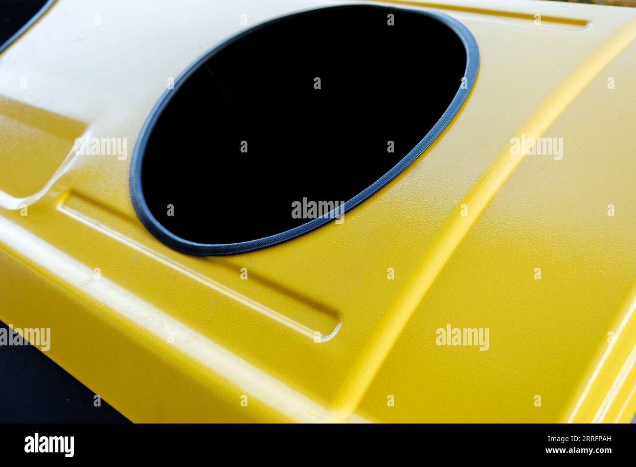 A yellow plastic recycling garbage can is a container specifically ...