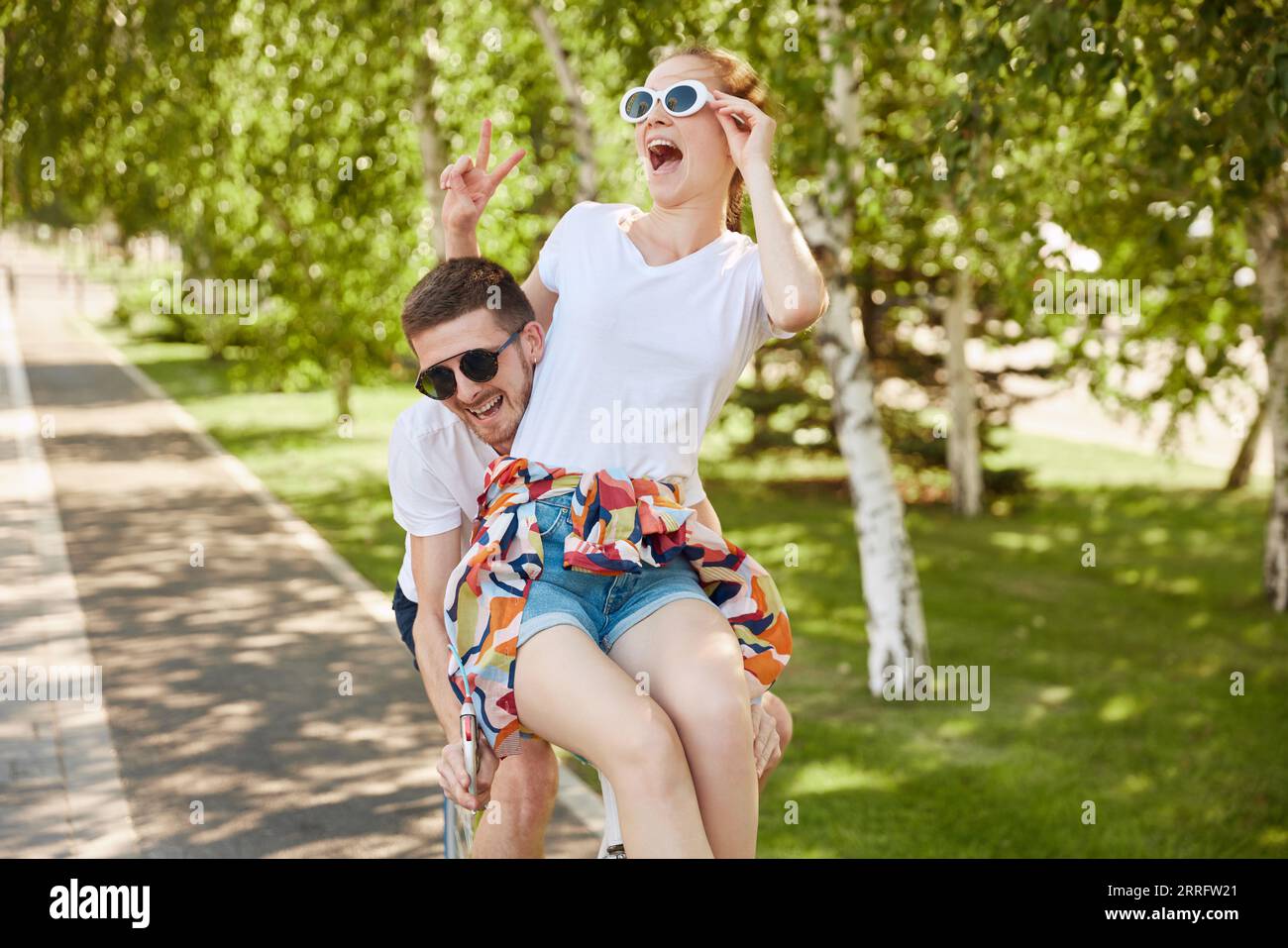 happy couple in love riding bicycle. Handsome guy and young sensual ...