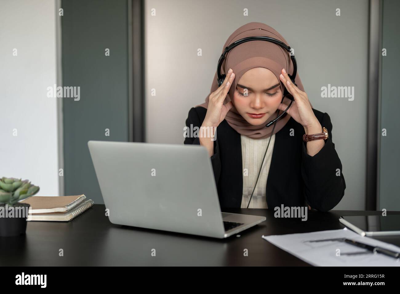 A serious and thoughtful Asian Muslim female customer call centre ...