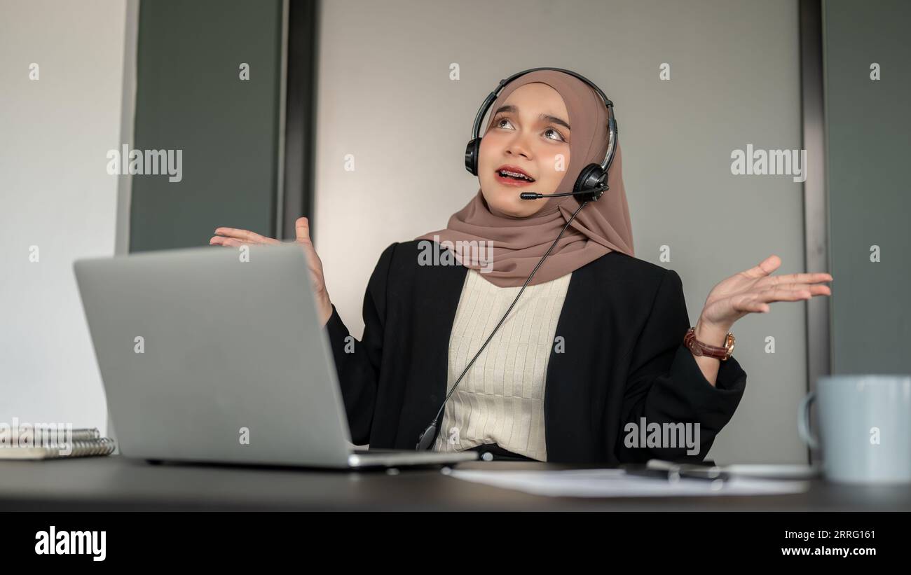 A cheerful and attractive Asian Muslim female call centre operator or ...