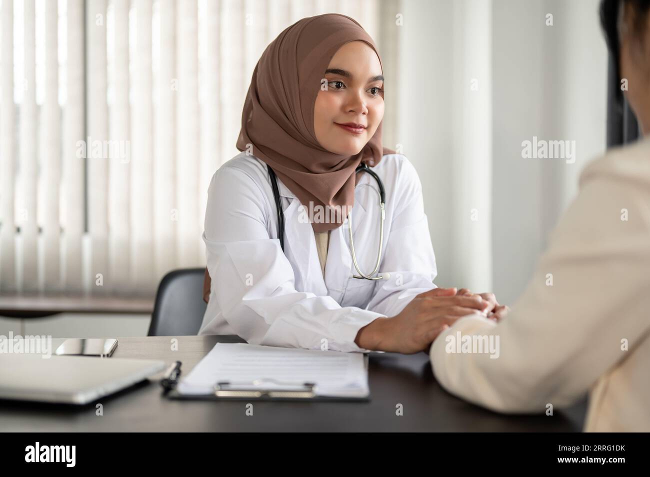 A caring and professional Asian Muslim female doctor in a uniform and ...