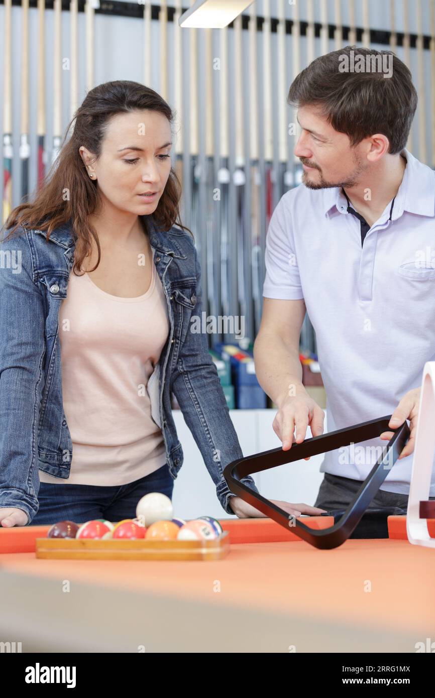 man setting up balls in rack for a pool game Stock Photo - Alamy