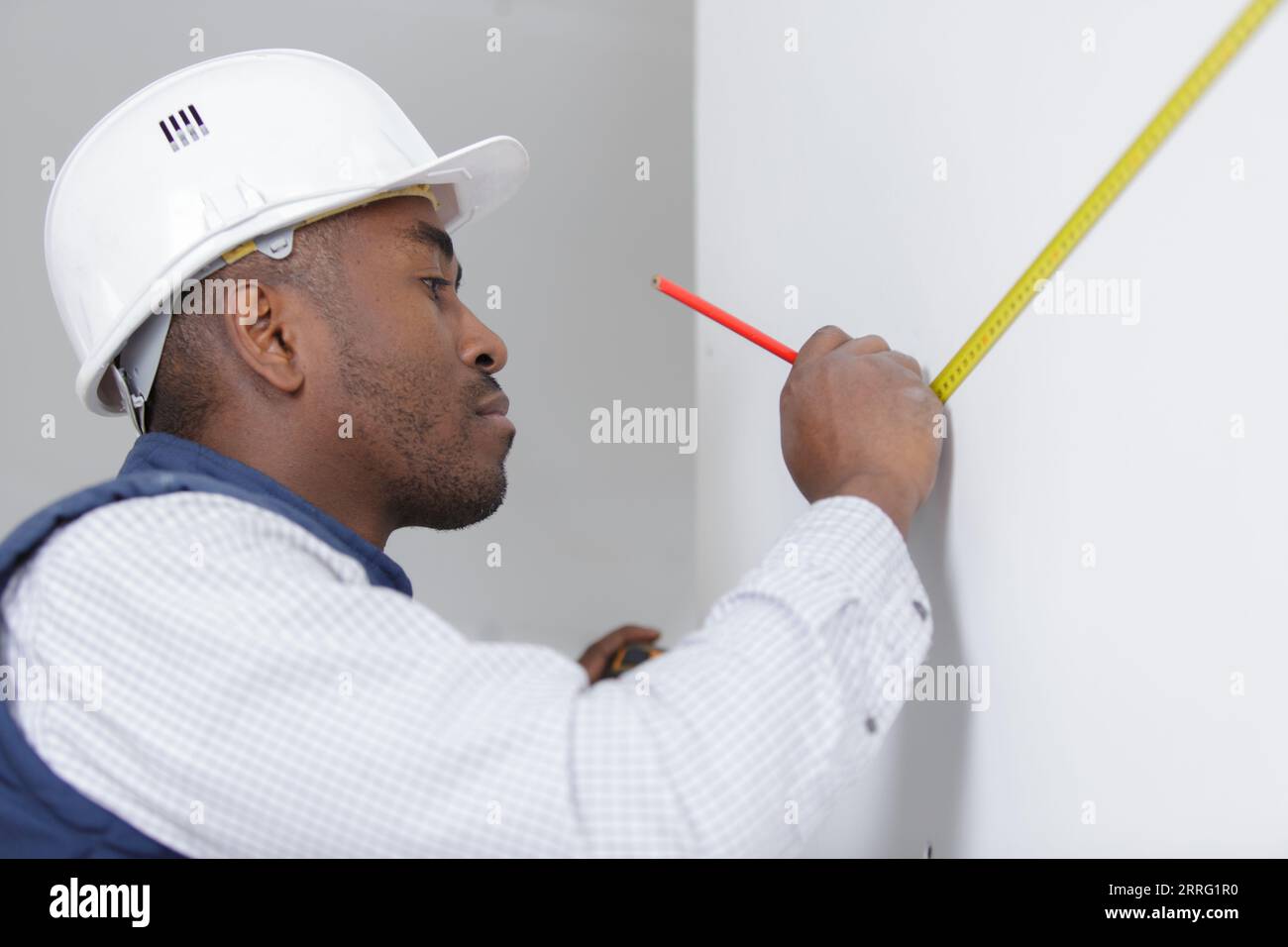 man measuring the wall with a measuring tape Stock Photo - Alamy