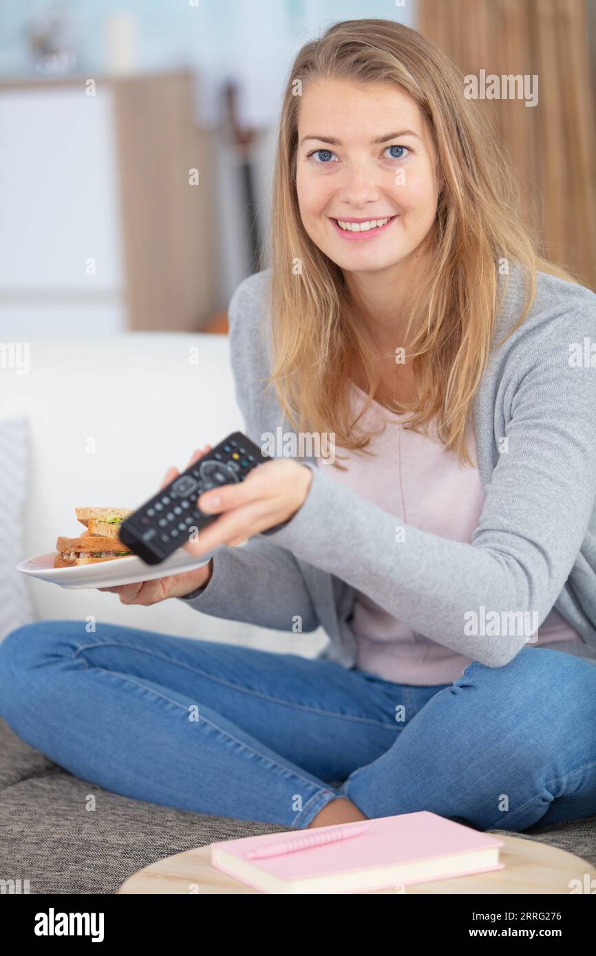 happy woman snacking and zapping Stock Photo - Alamy
