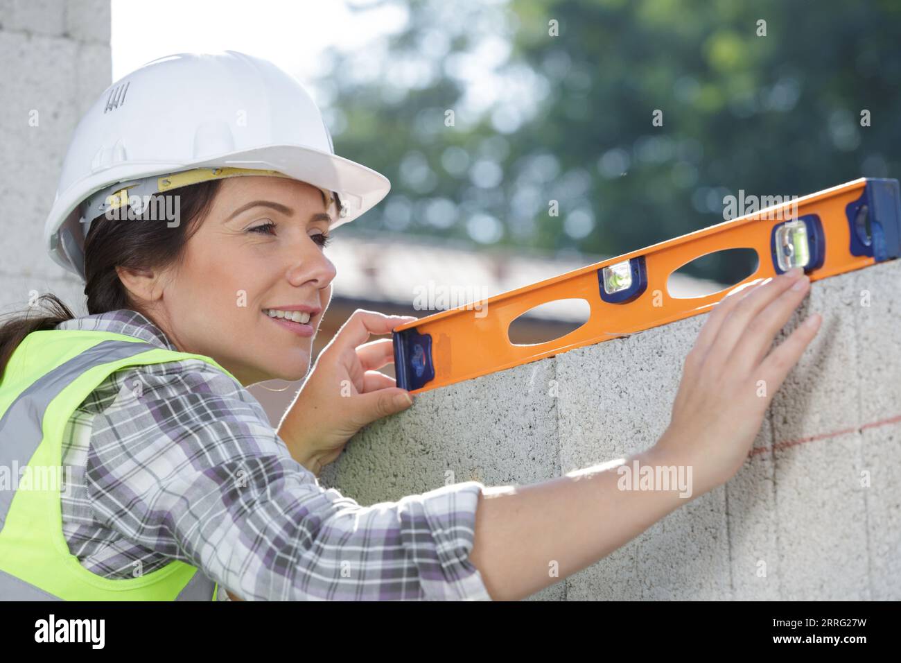 female construction holding a level Stock Photo - Alamy