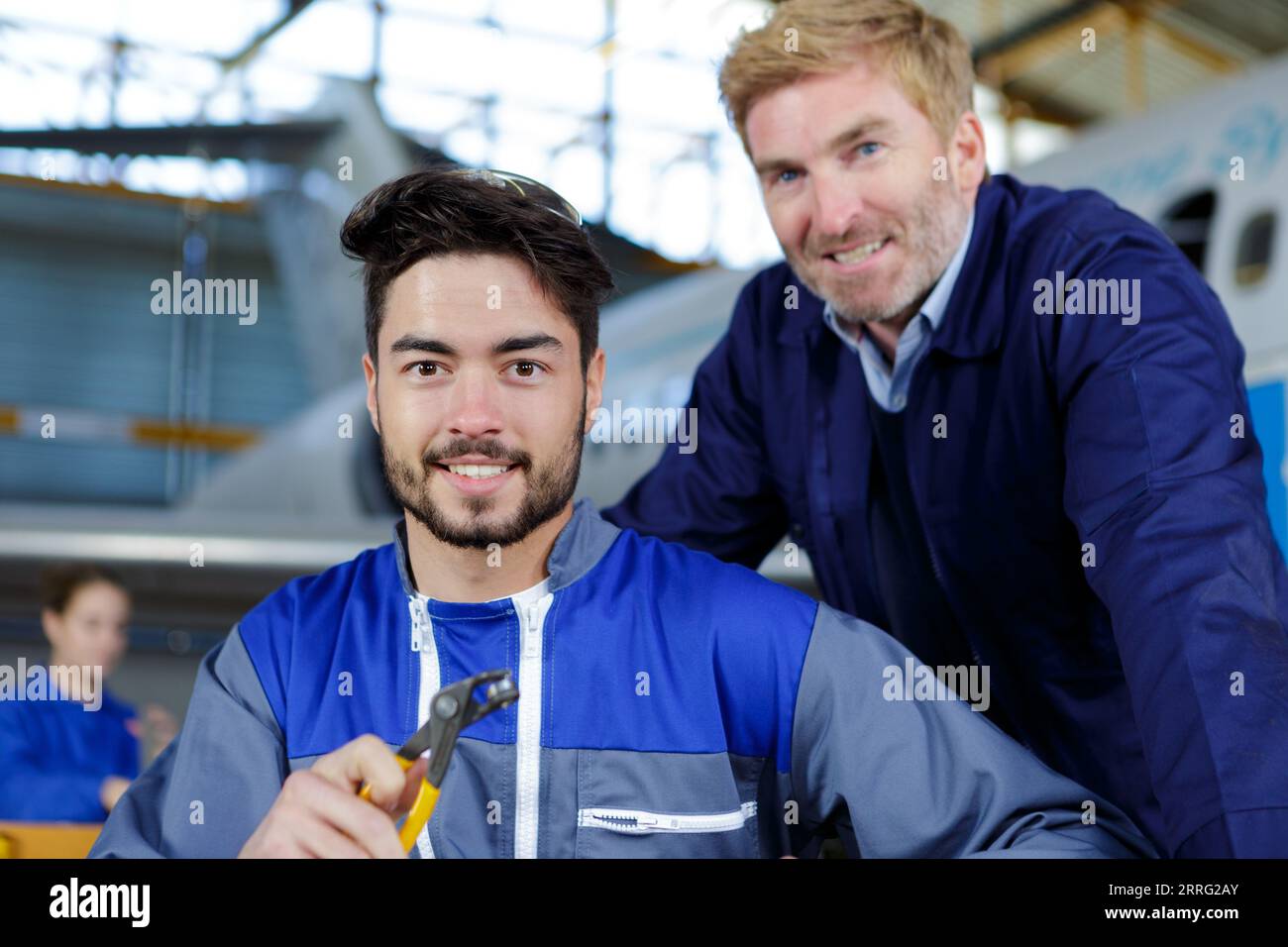 two mechanics working on a small aircraft in a hangar Stock Photo - Alamy