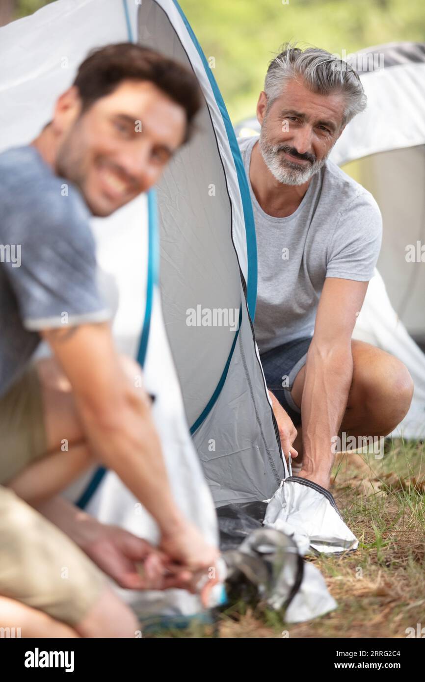 two men are setting up a tent Stock Photo - Alamy