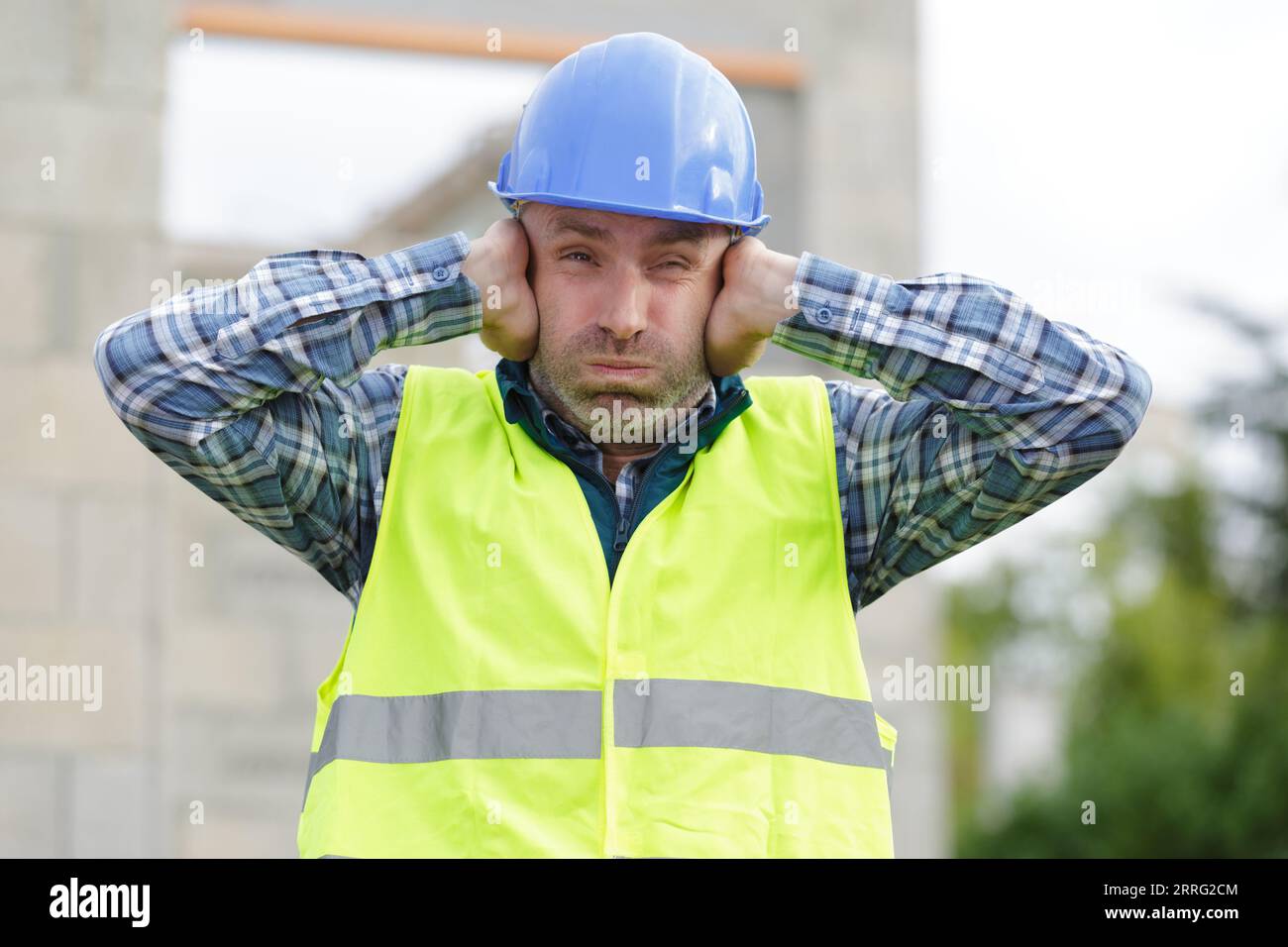 male construction worker covering his ears Stock Photo - Alamy