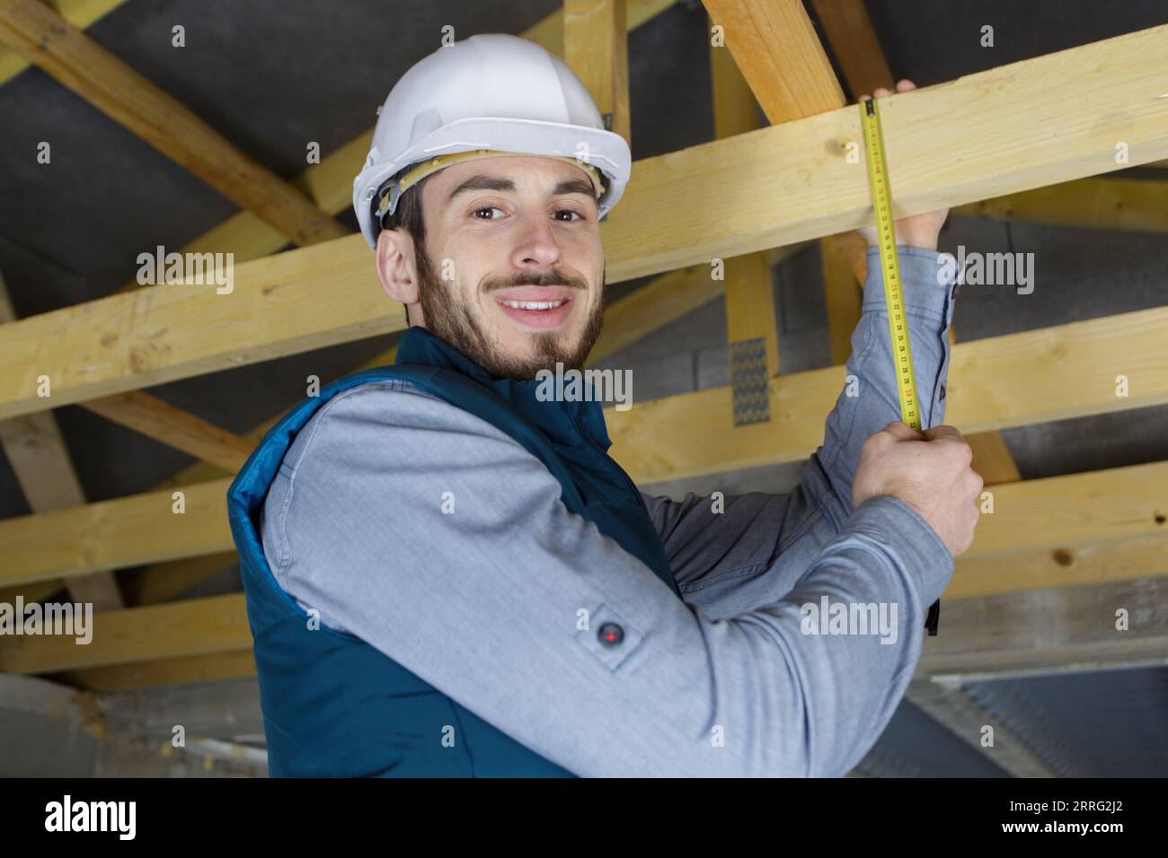 man measuring wood ceiling with tape measure Stock Photo - Alamy