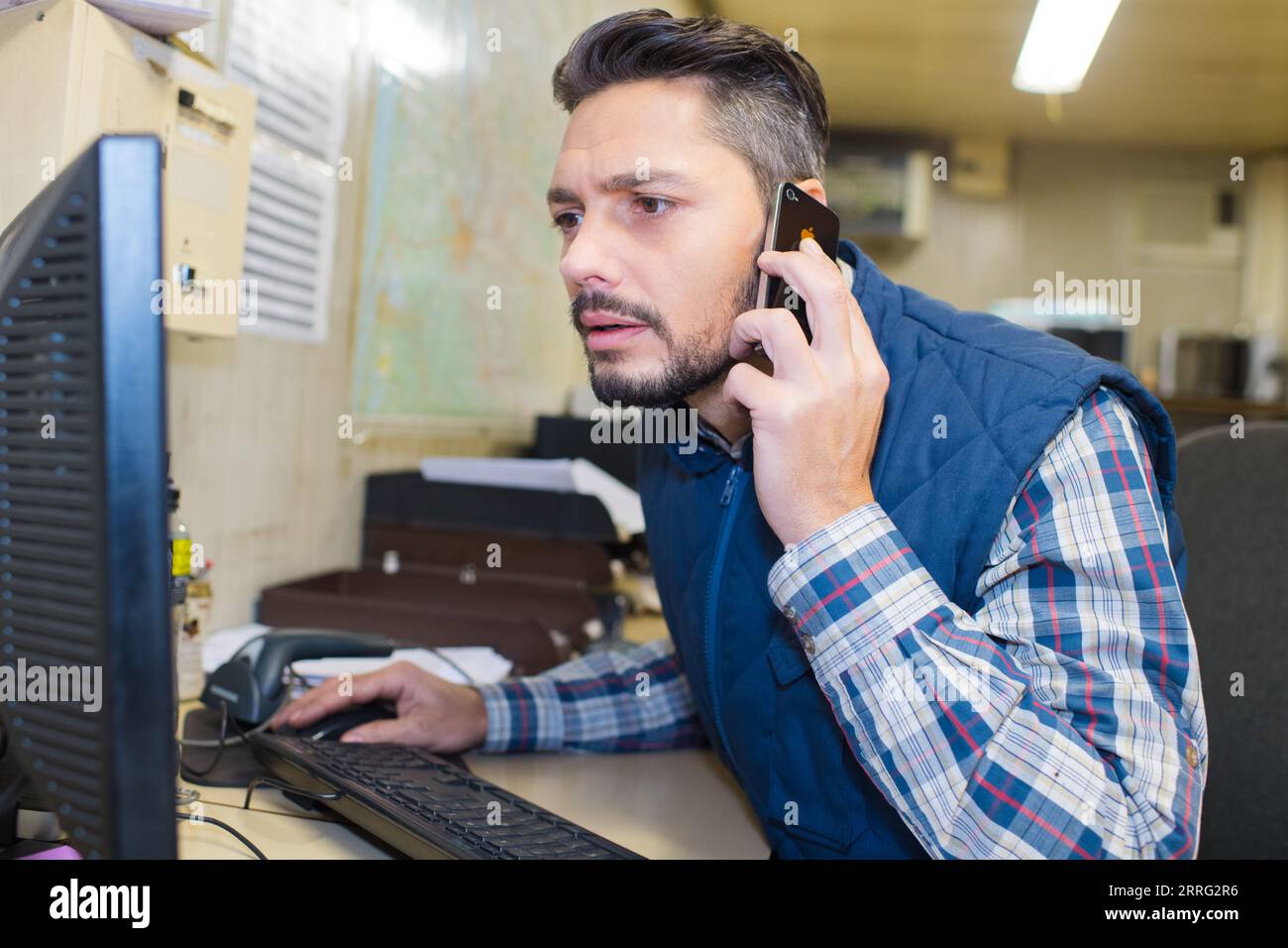 supervisor using cell phone and pc at warehouse Stock Photo - Alamy