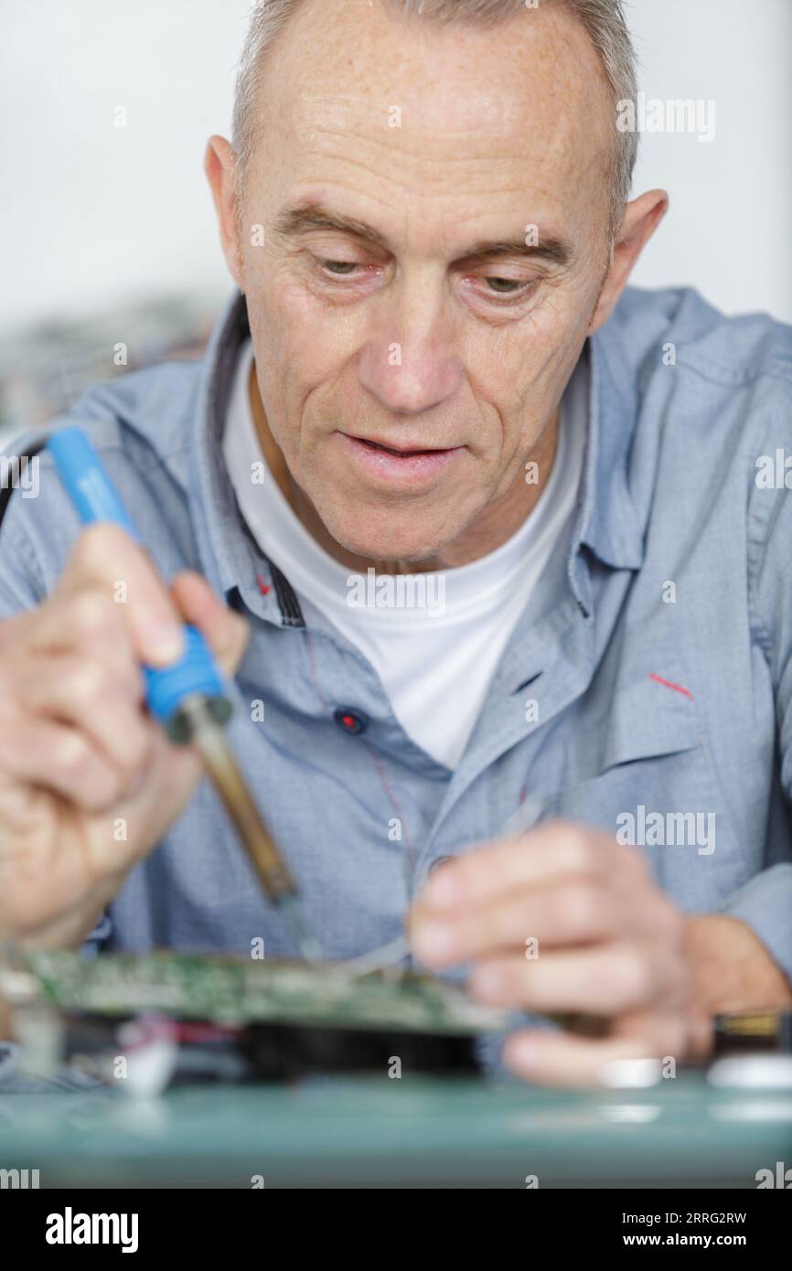mature man soldering a pc board Stock Photo - Alamy