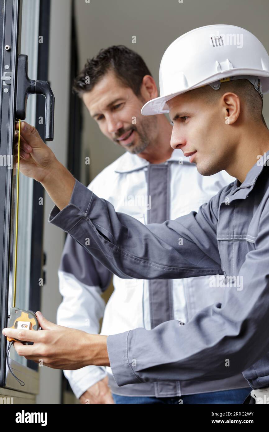 man measuring window prior to installation Stock Photo - Alamy