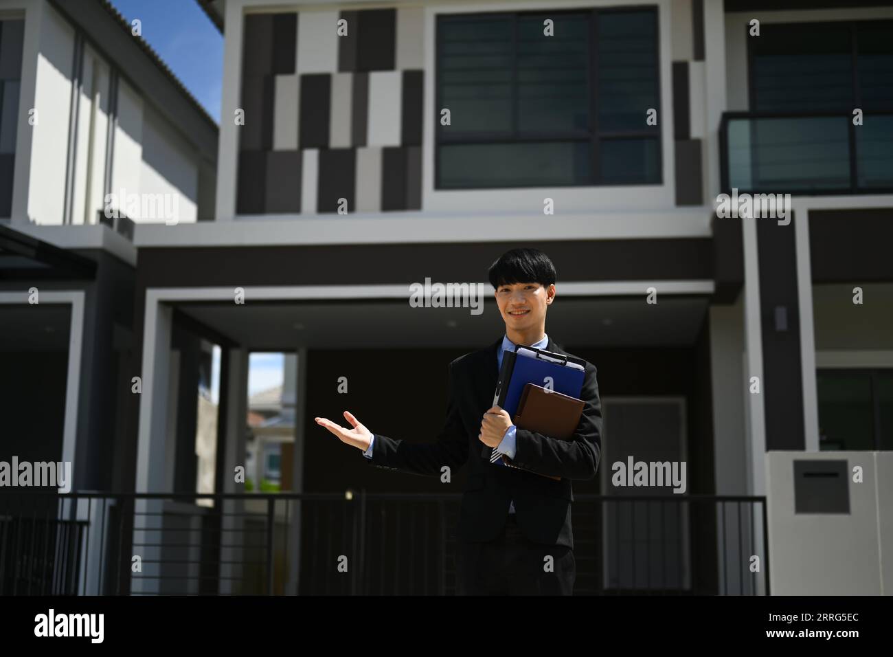Professional realtor or real estate agent standing in front of house ...