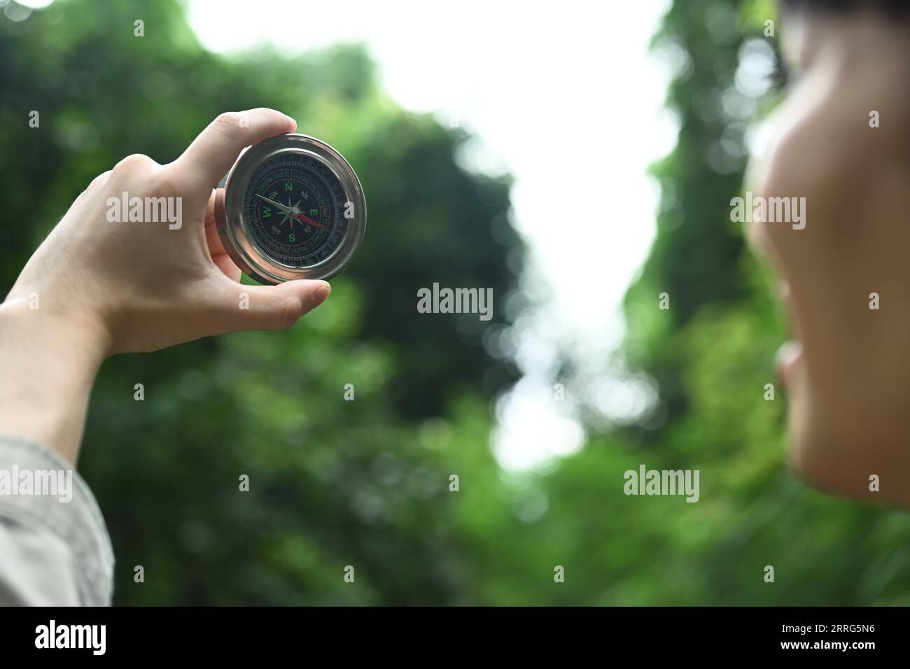 Male hiker using compass for directions in the forest, enjoying his ...