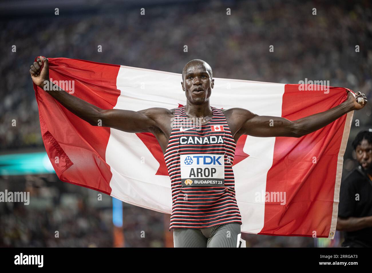 Marco Arop celebrating her gold medal with her country's flag in the ...