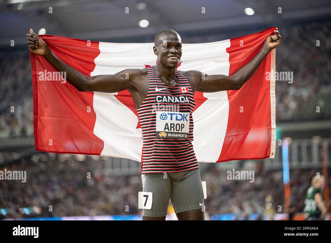 Marco Arop celebrating her gold medal with her country's flag in the ...