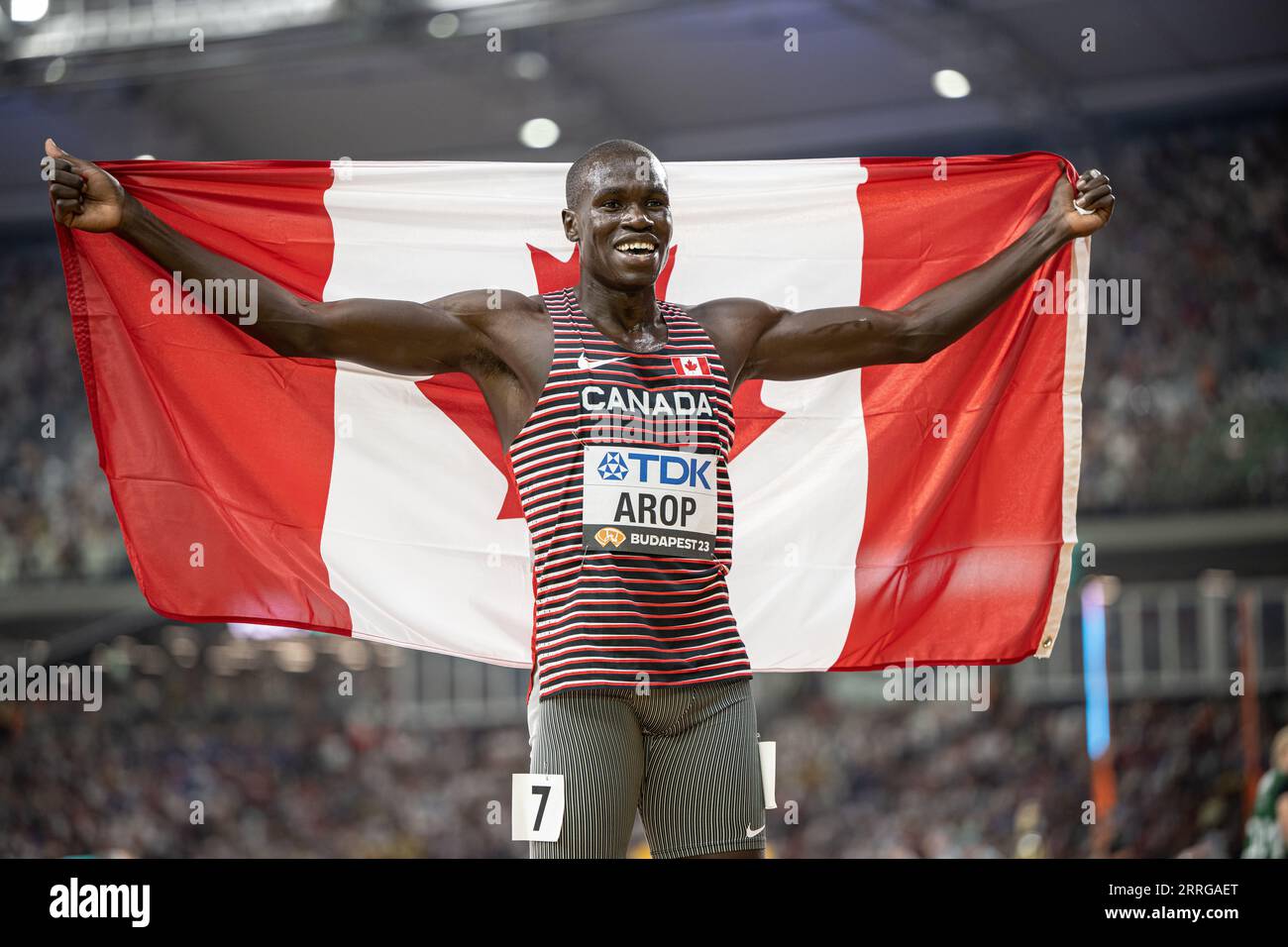 Marco Arop celebrating her gold medal with her country's flag in the ...