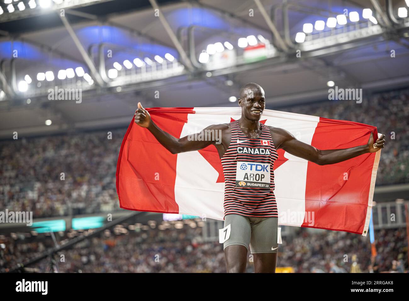 Marco Arop celebrating her gold medal with her country's flag in the ...