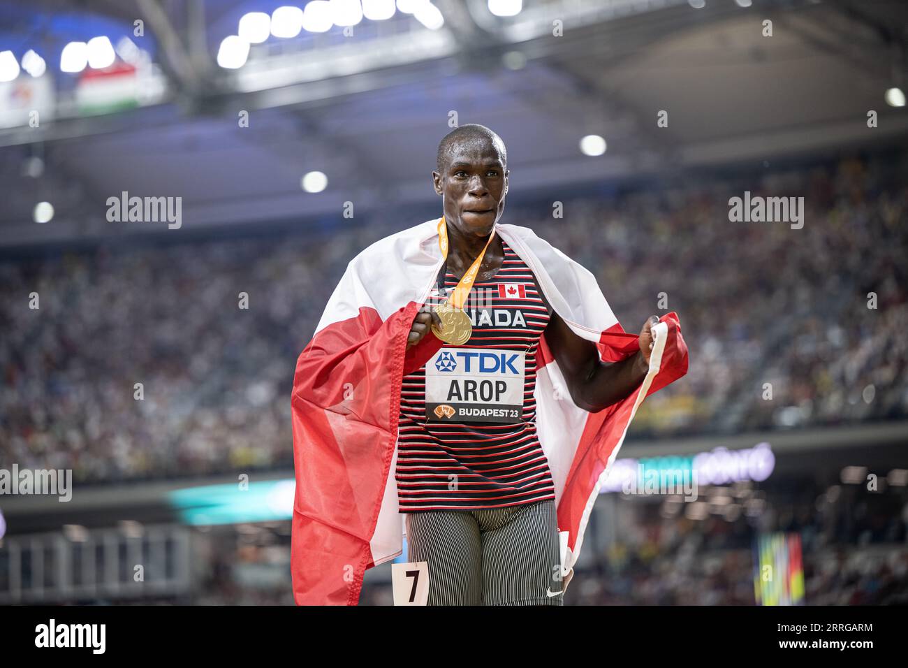 Marco Arop celebrating her gold medal with her country's flag in the ...