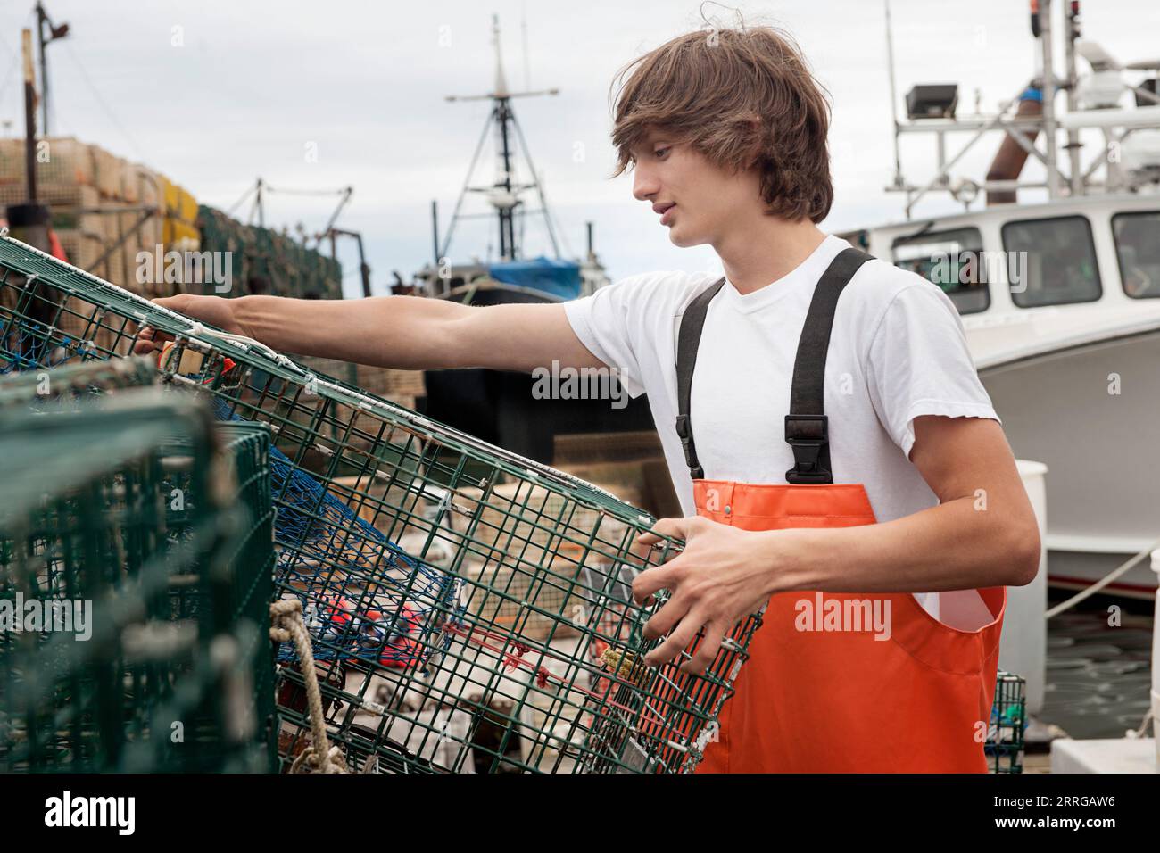Teenage lobster fisherman in Portland, Maine, grabs traps to load on ...