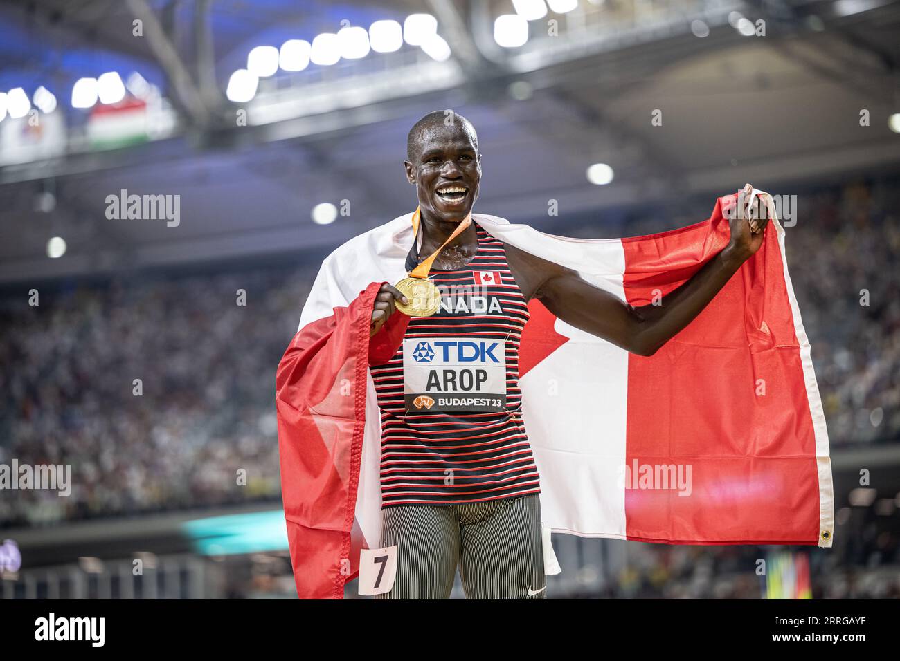 Marco Arop celebrating her gold medal with her country's flag in the ...