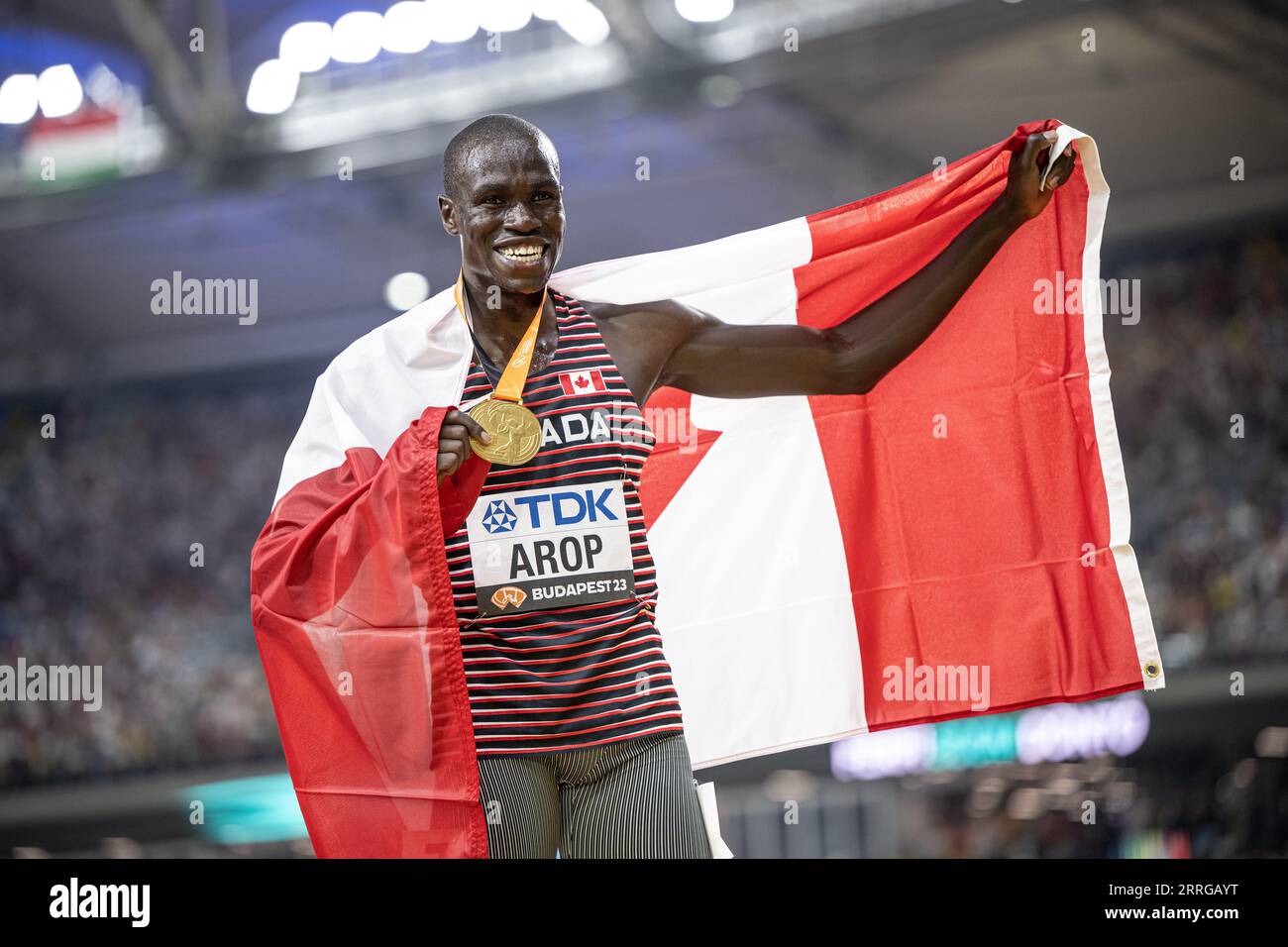 Marco Arop celebrating her gold medal with her country's flag in the ...