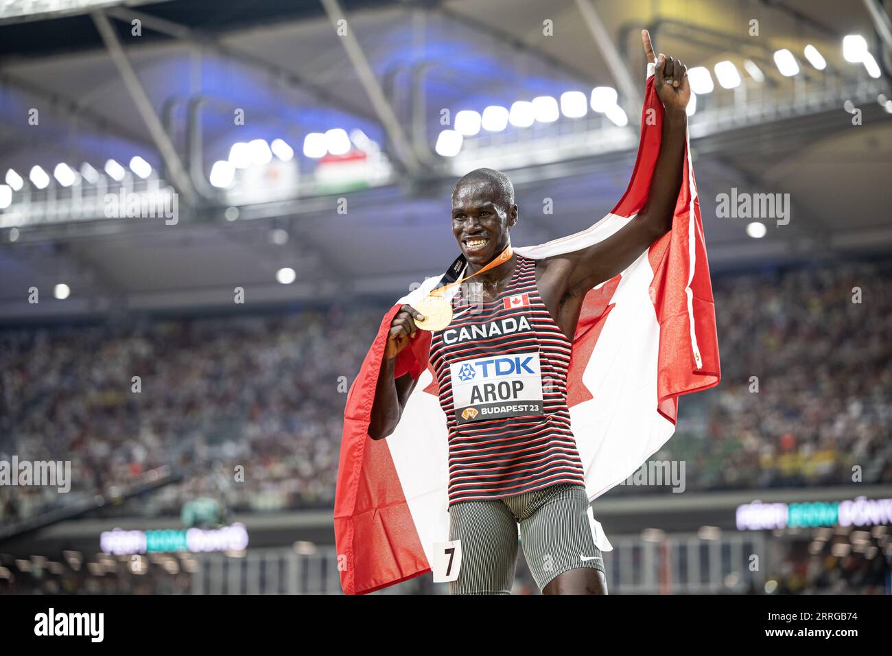 Marco Arop celebrating her gold medal with her country's flag in the ...