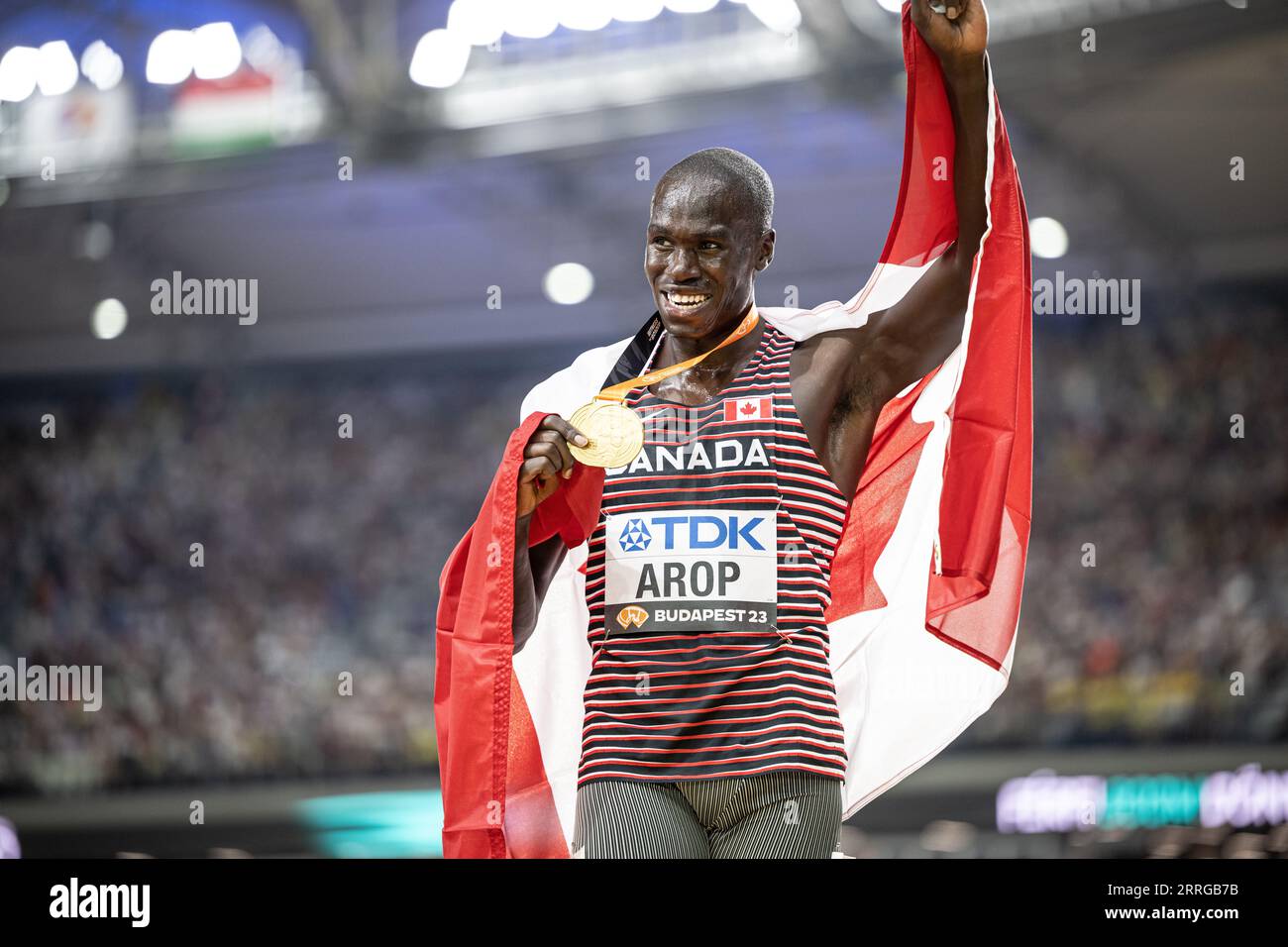 Marco Arop celebrating her gold medal with her country's flag in the ...